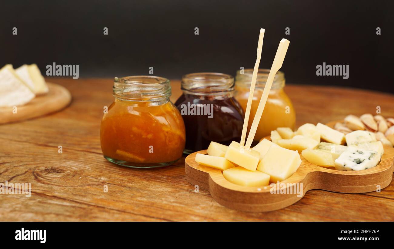 Jars of homemade jam and honey in glass jars and a variety of cheeses ...