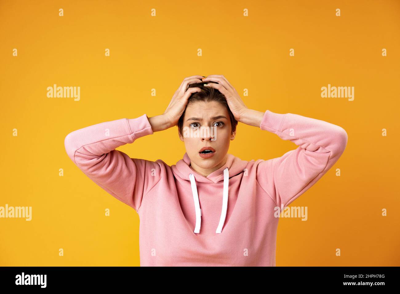 Surprised young woman shouting over yellow background Stock Photo - Alamy