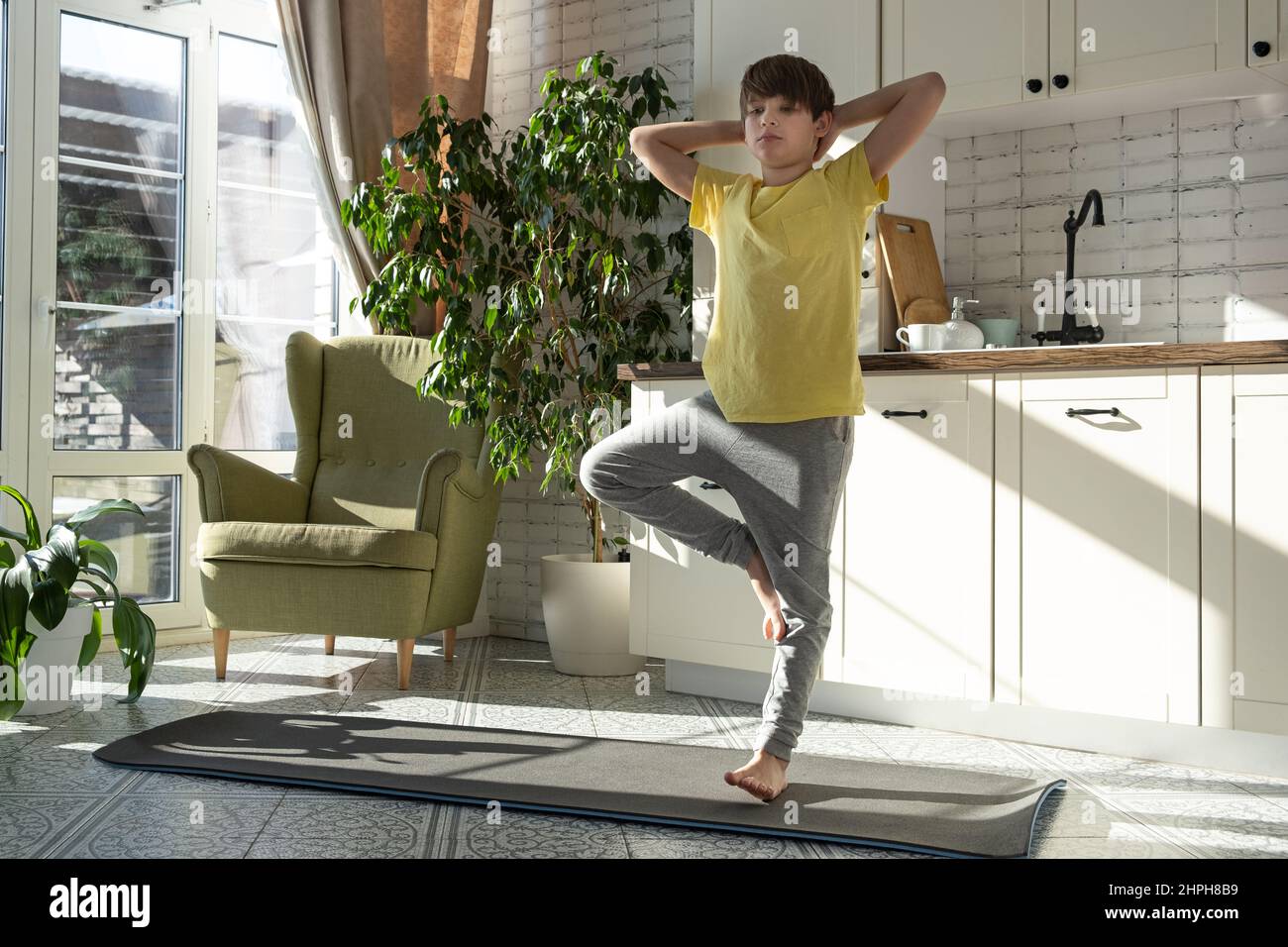 Little boy practicing yoga, stretching, fitness at home. Distant online ...
