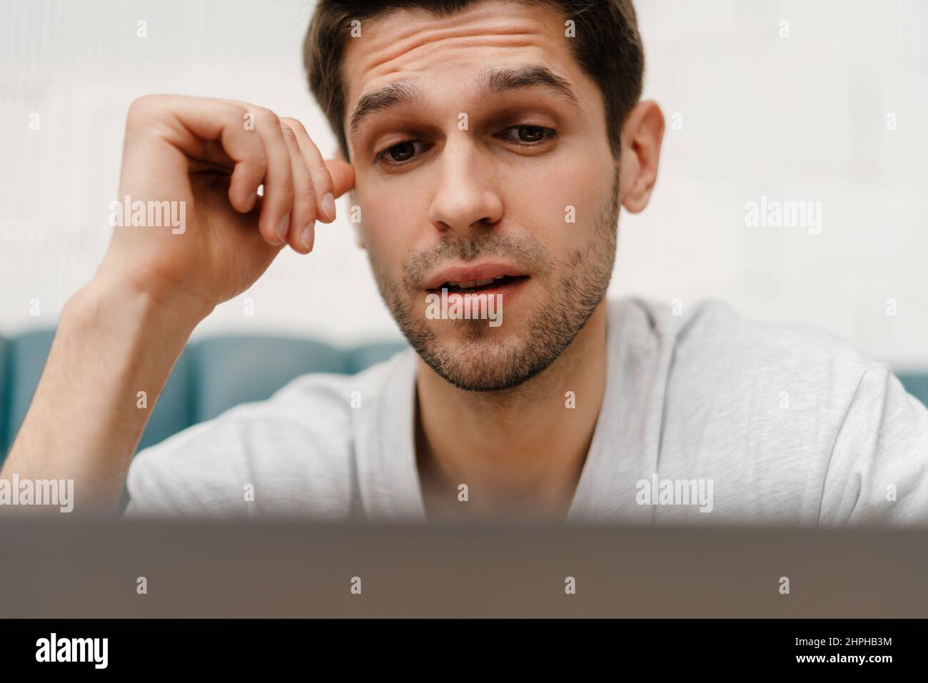Confused young man student sitting in cafe indoors with laptop computer, looking at screen Stock ...