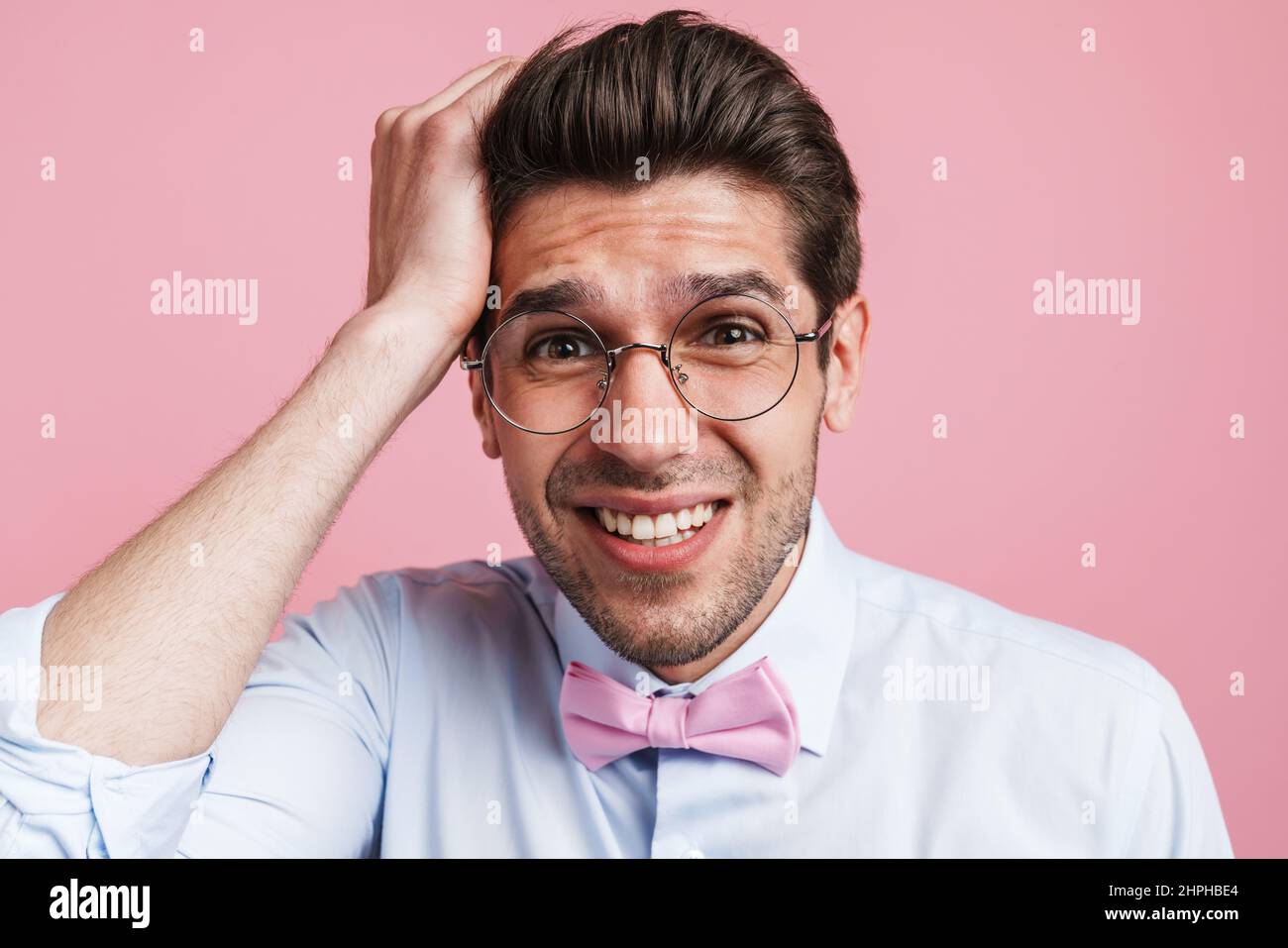 Portrait of a confused frowning young brunette nerd man wearing shirt ...