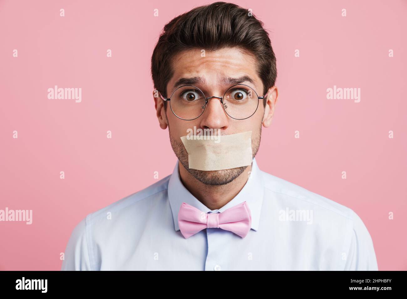 Young white man wearing bow tie posing with moth glued shut isolated ...