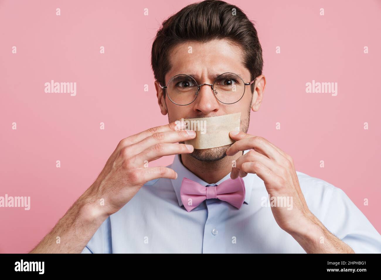 Young white man wearing bow tie posing with moth glued shut isolated ...