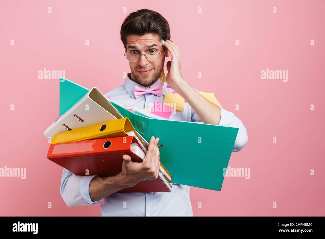 Stressed mid aged man employee holding stack of folders with documents ...