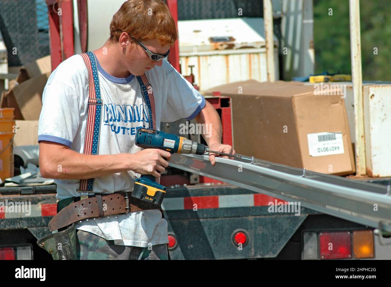 Installation of rain water run off gutters by young men on ladders and ...