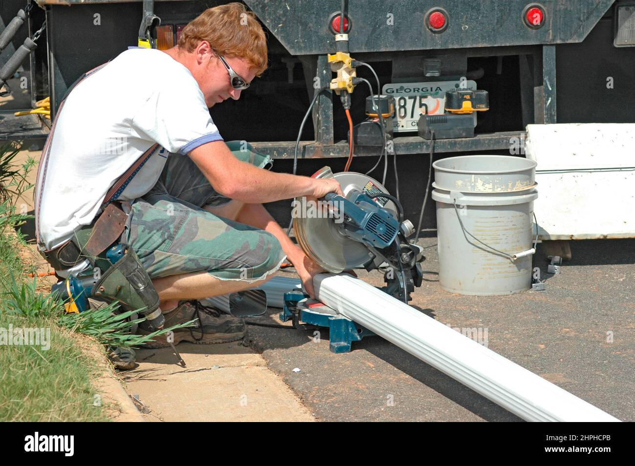Installation of rain water run off gutters by young men on ladders and ...