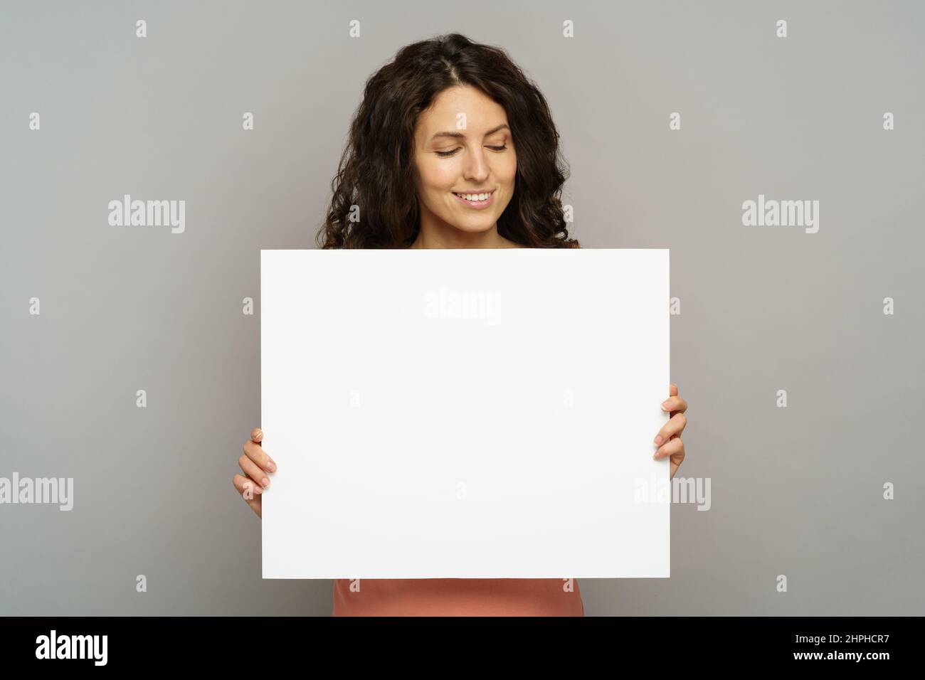 Happy young woman hold blank placard look to copy space with smile ...