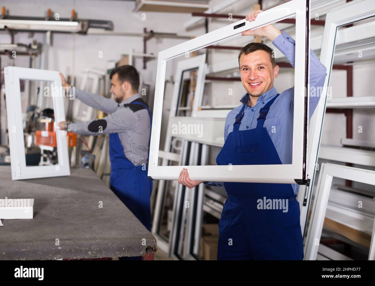 Production workers in coverall with different finished PVC profiles and ...