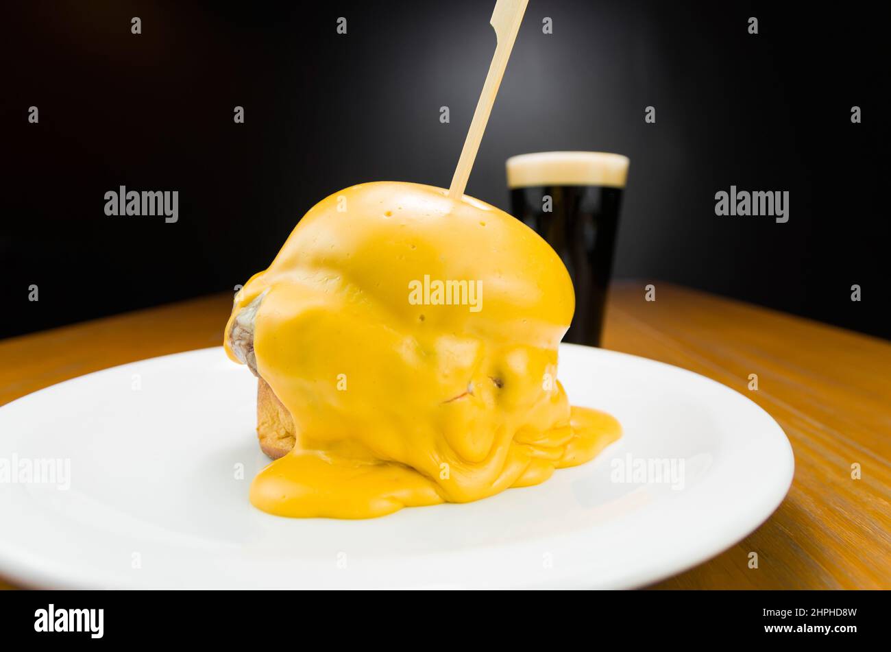 Delicious close-up of hamburger covered in cheddar cheese sauce Stock ...