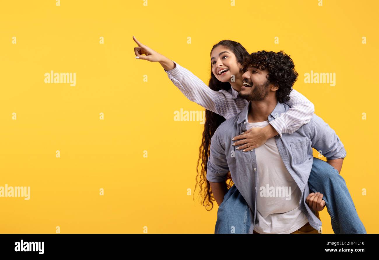 Excited young indian couple having fun and lady piggybacking guy and ...