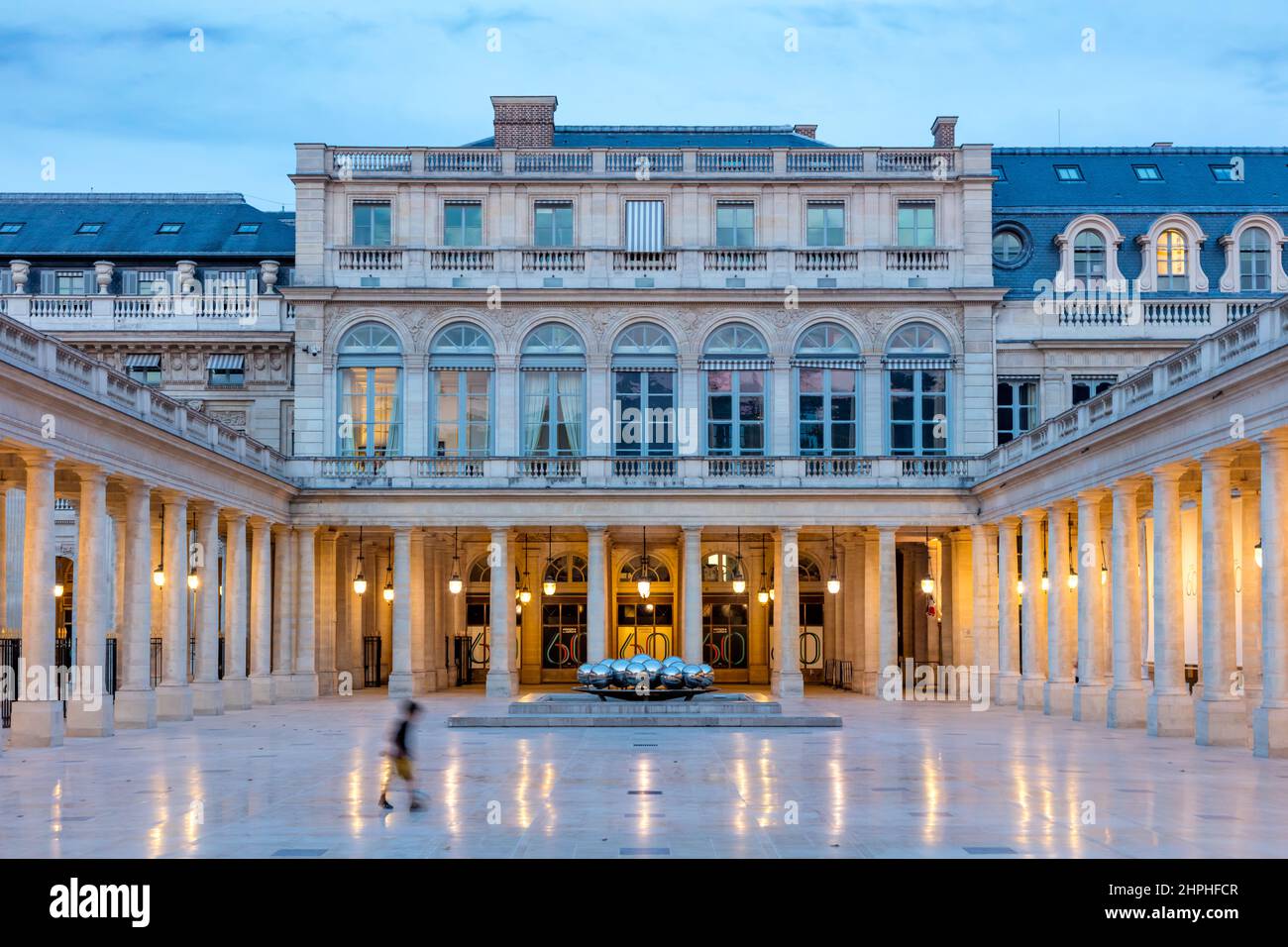 Young boy walks through the courtyard of Palais Royal in the evening ...
