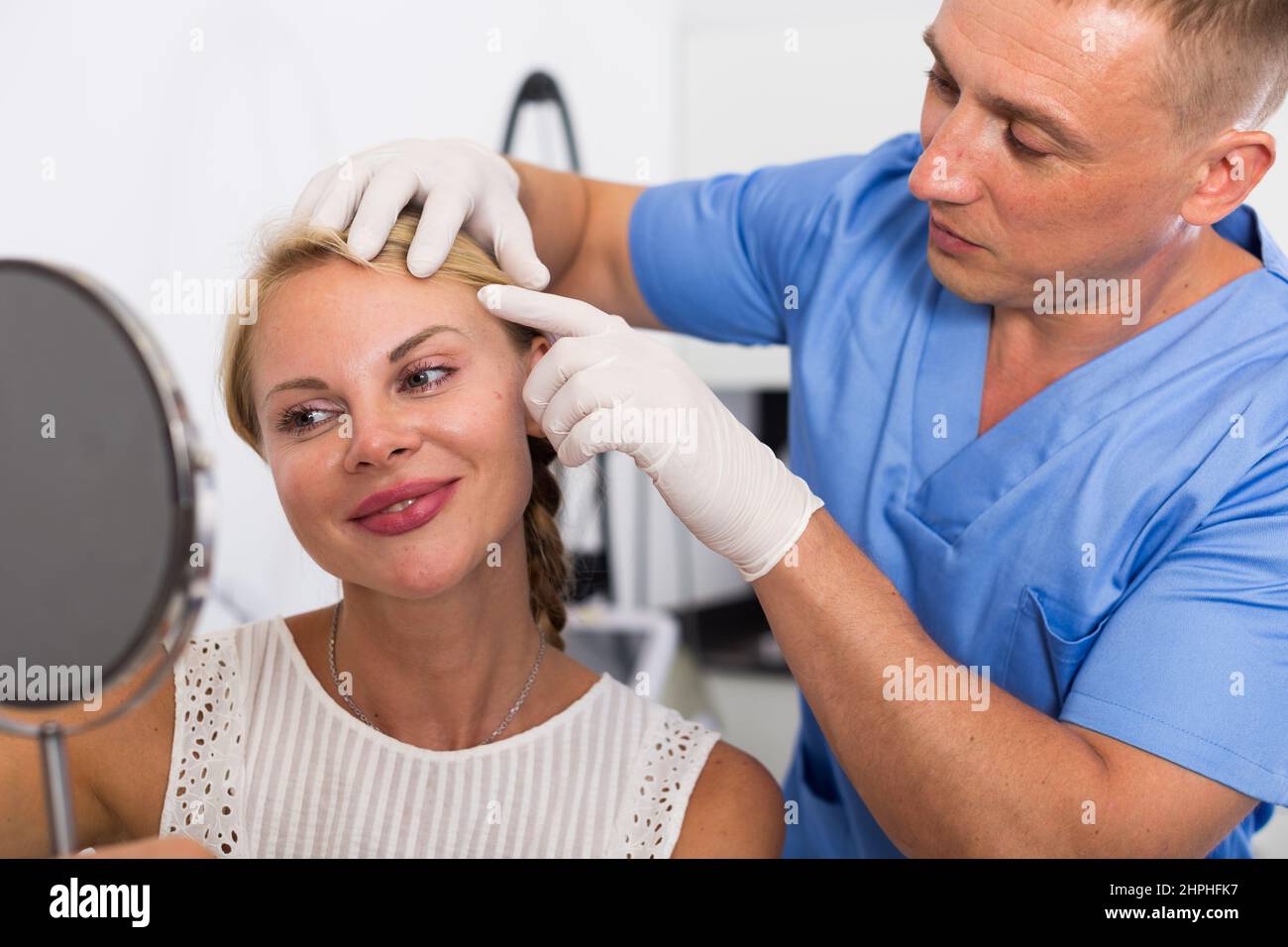 Man doctor is preparing female patient to procedure Stock Photo - Alamy