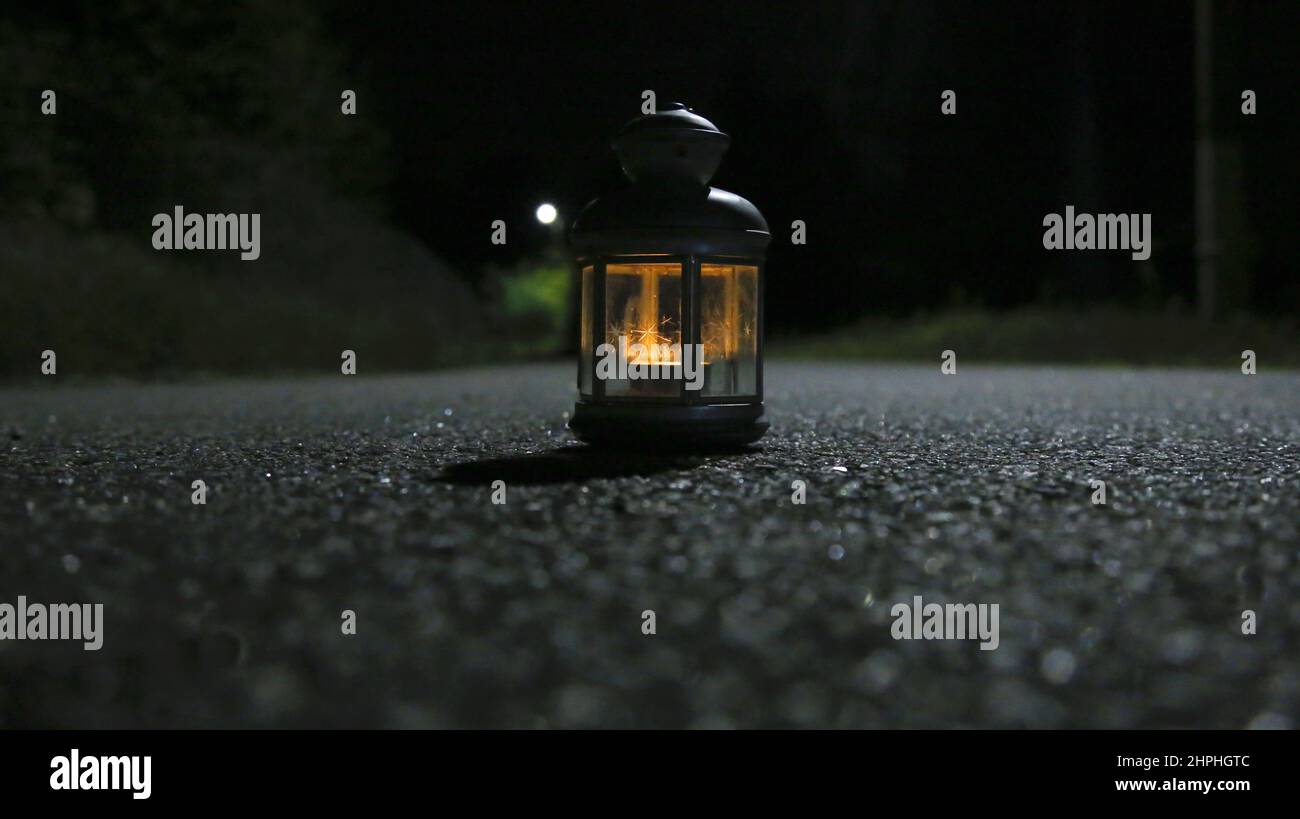 A burning lantern in the dark that illuminates the night road Stock ...