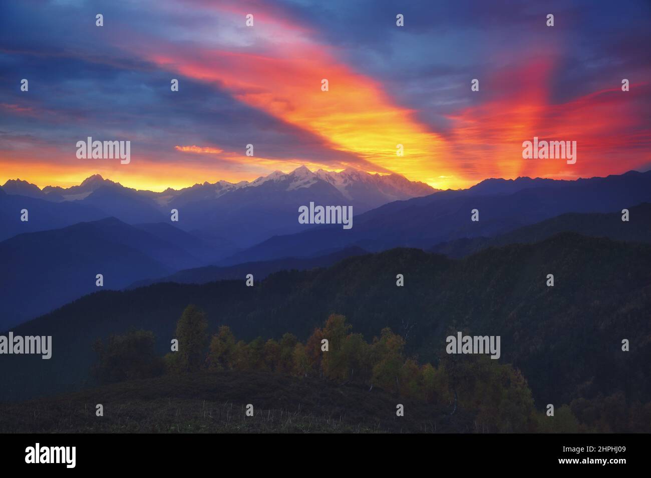 Fantastic red sunbeams with overcast sky at the foot of Mt. Ushba ...