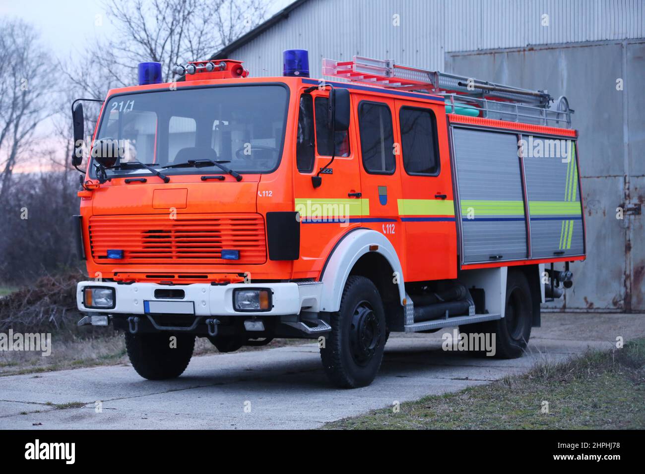 Red fire engine car parked with emergency ladder without firemen on ...
