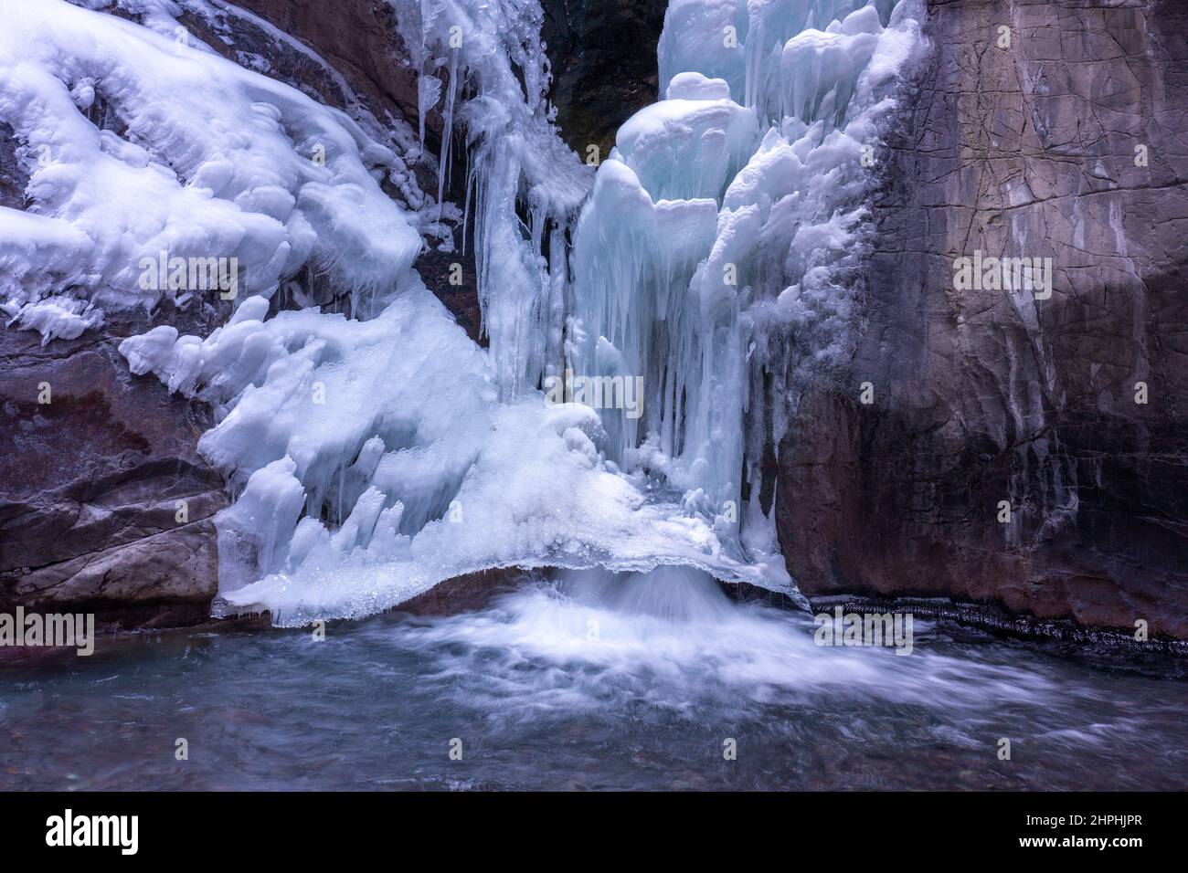 Water cascades out of the bottom of the frozen Box Canyon waterfall in ...