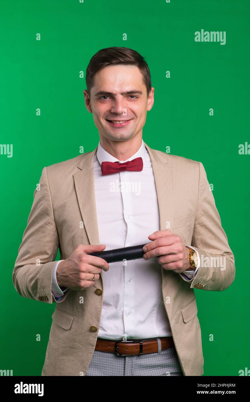 Portrait of male announcer holding microphone, isolated on green, white ...