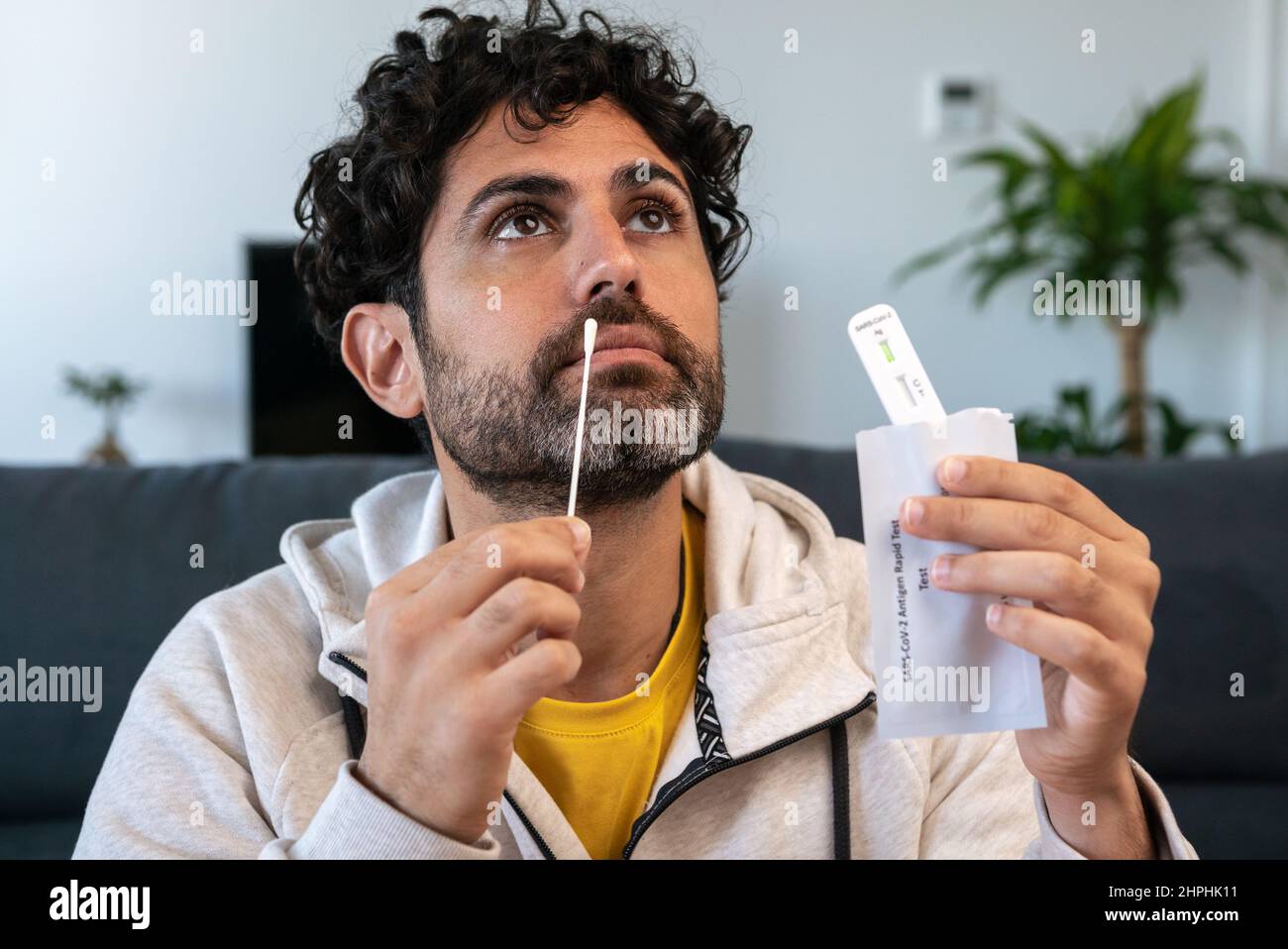 Portrait of relaxed man taking a self swabbing home tests for Covid19 ...