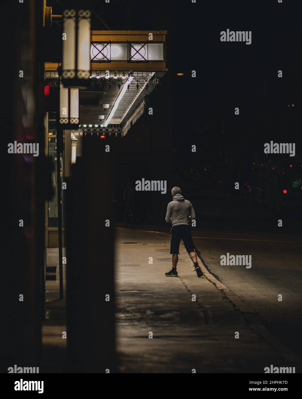 Lonely man walking on a street at night Stock Photo - Alamy