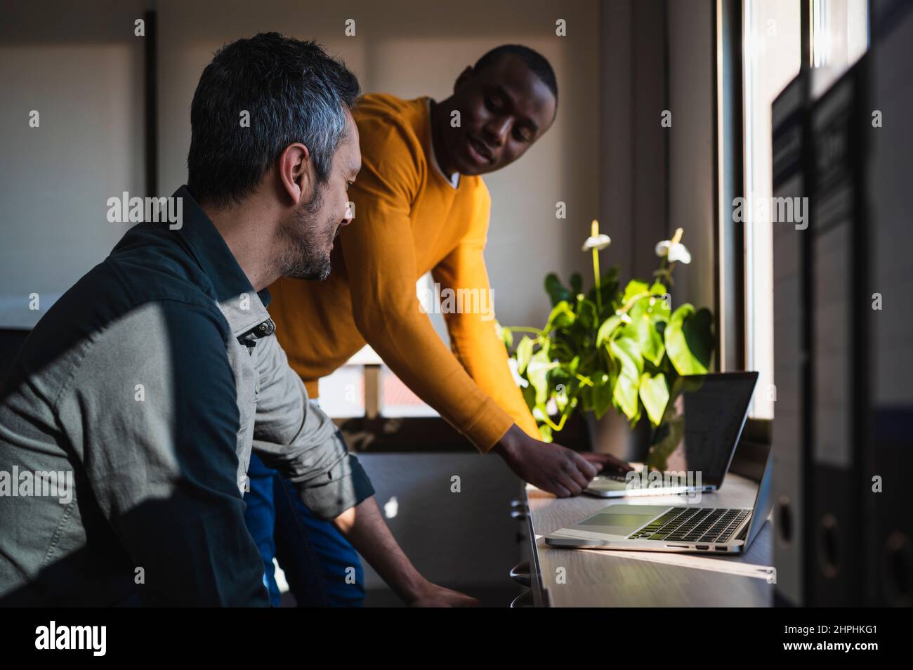 Two colleagues laughing while working in an office Stock Photo - Alamy
