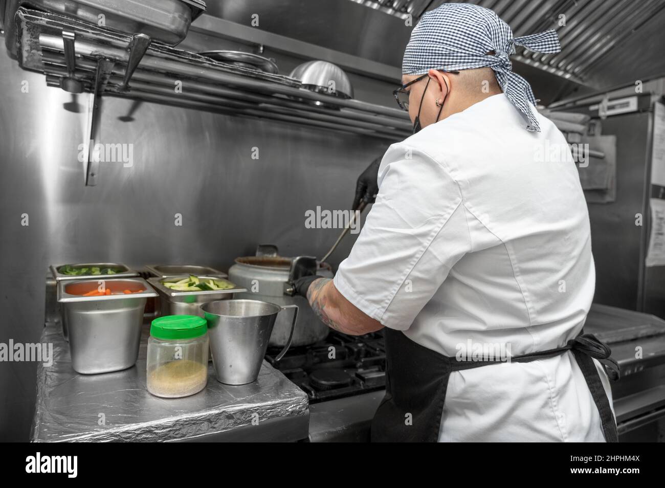 Side view of female chef working in commercial kitchen. High quality ...