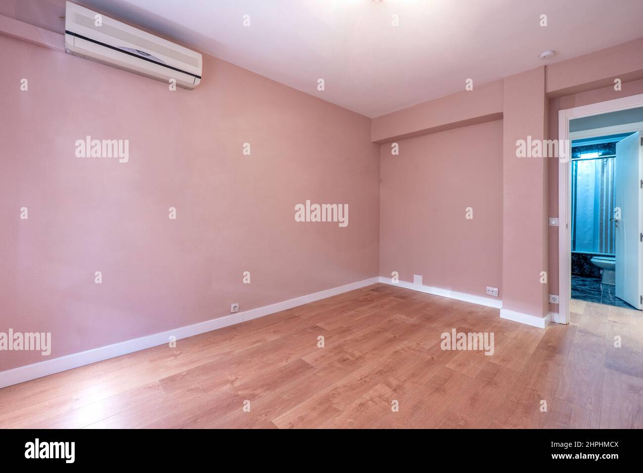 Empty room painted with a pastel pink paint tone, wooden floorboards ...