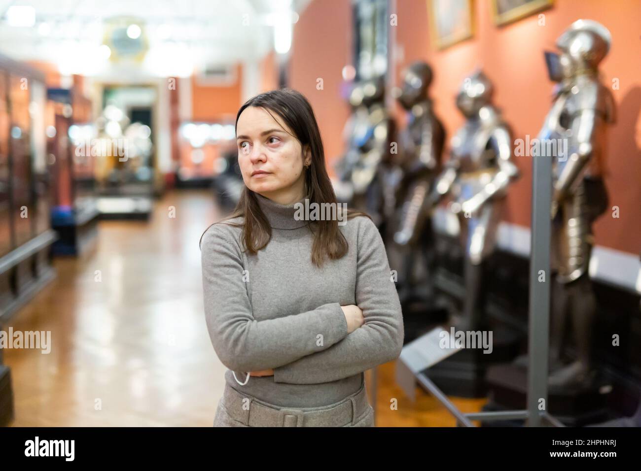 Female museum visitor examining with interest ancient armor Stock Photo ...