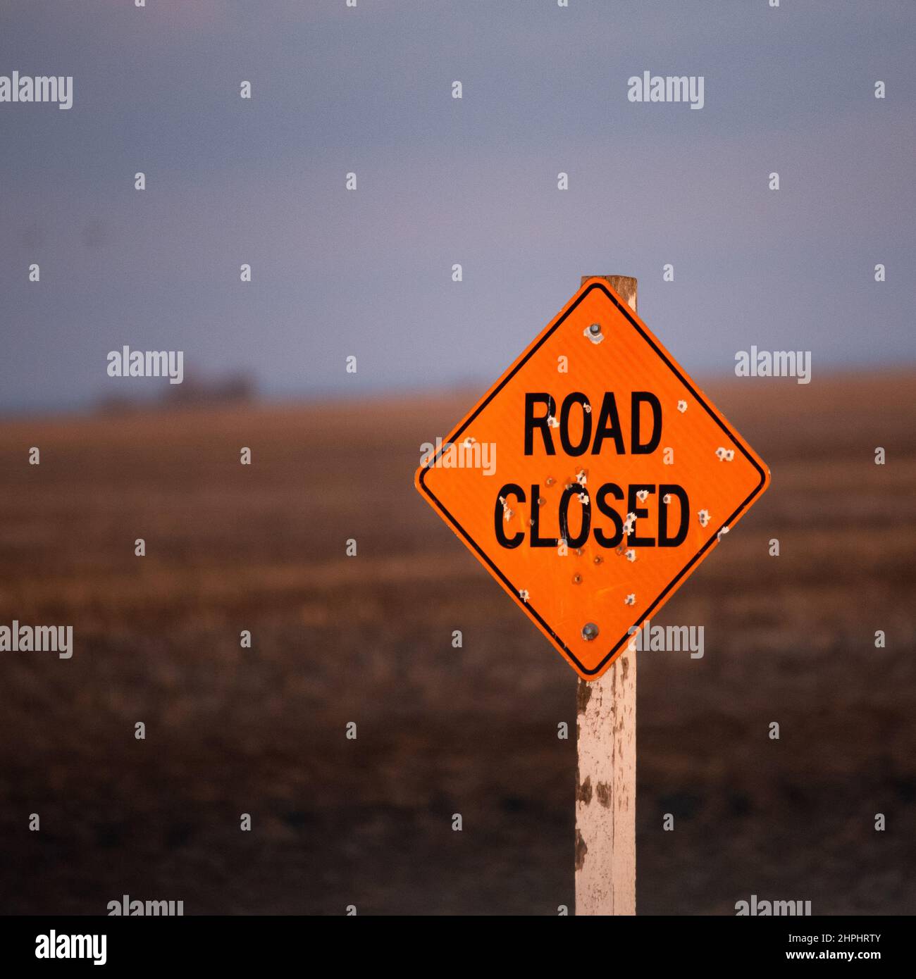 Rural road closed sign with bullet holes Stock Photo - Alamy