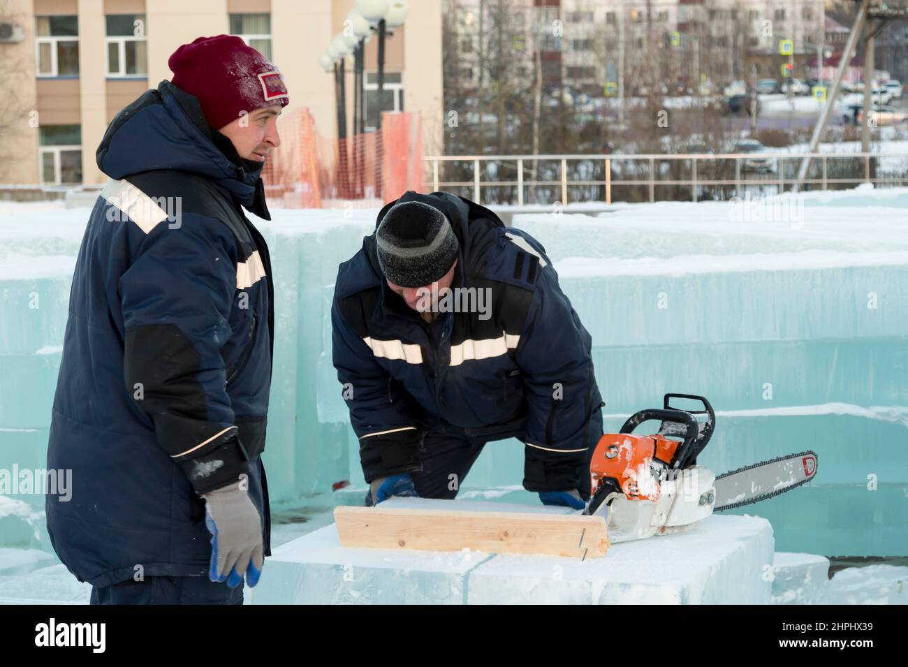Workers installers mark the ice block on the territory of the ice town ...