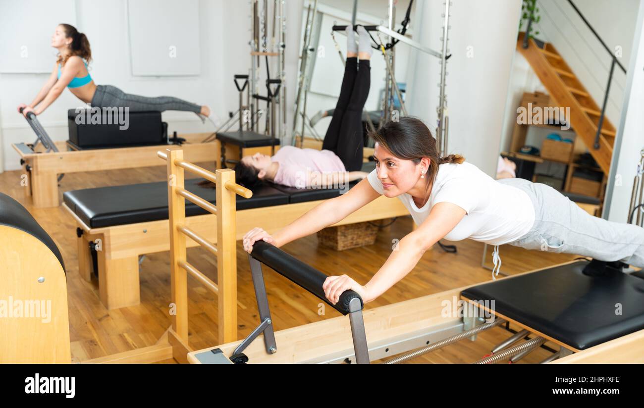 Women doing pilates exercises lying on pilates machines Stock Photo - Alamy
