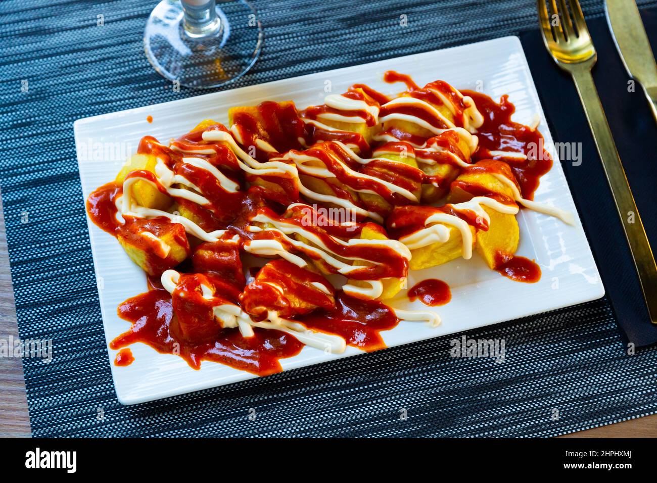 Spanish dish Patatas bravas with hot sauce Stock Photo - Alamy