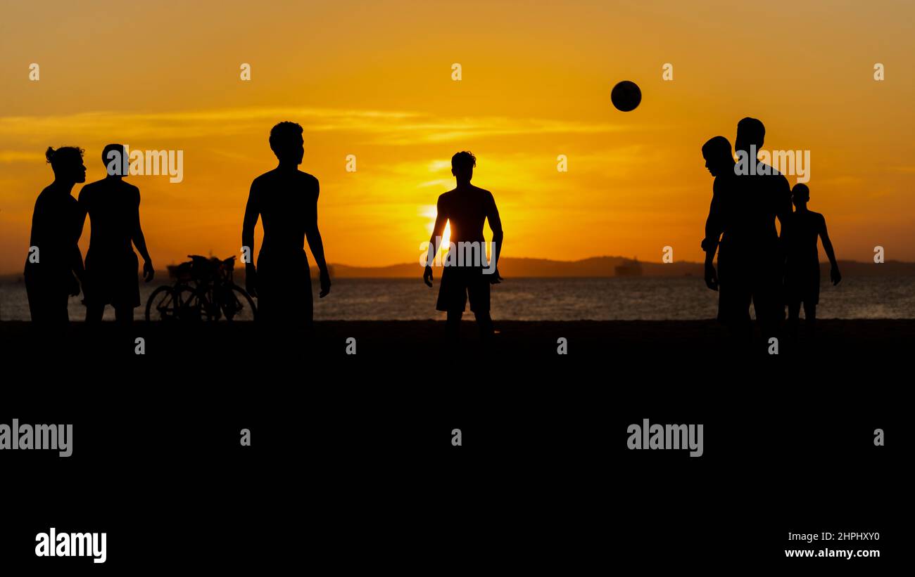 Young people playing beach soccer during sunset at Ribeira beach in ...