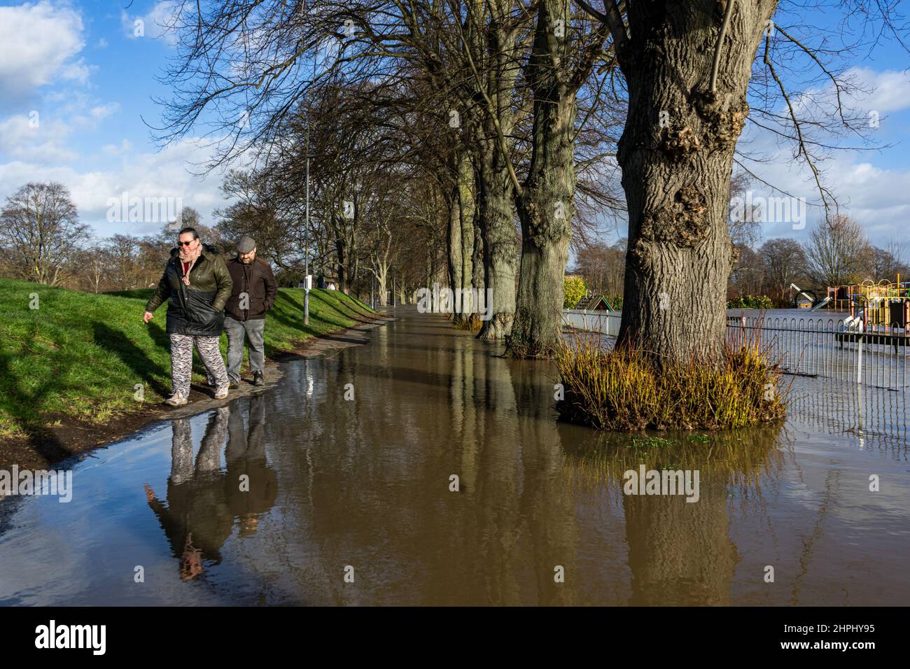 People walk along the edge of flood water as Storm Franklin brings ...