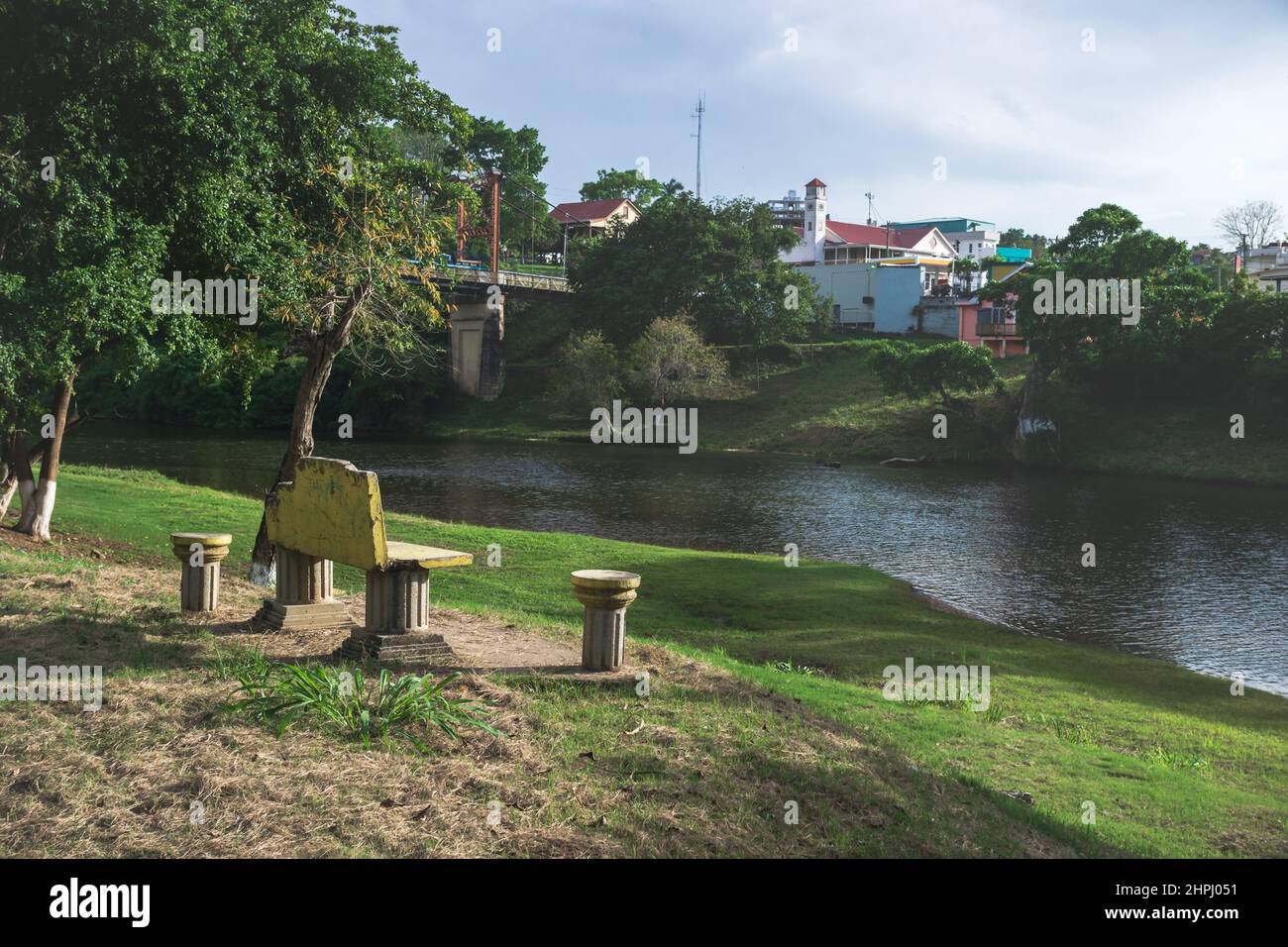 Yellow bench at the river side with Hawkesworth suspension bridge ...
