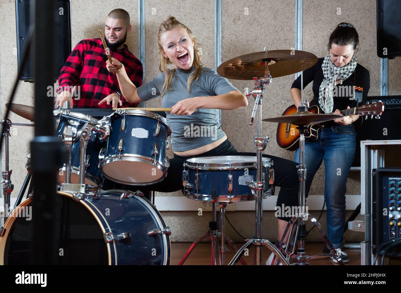 Music band with nice girl drummer rehearsing Stock Photo - Alamy