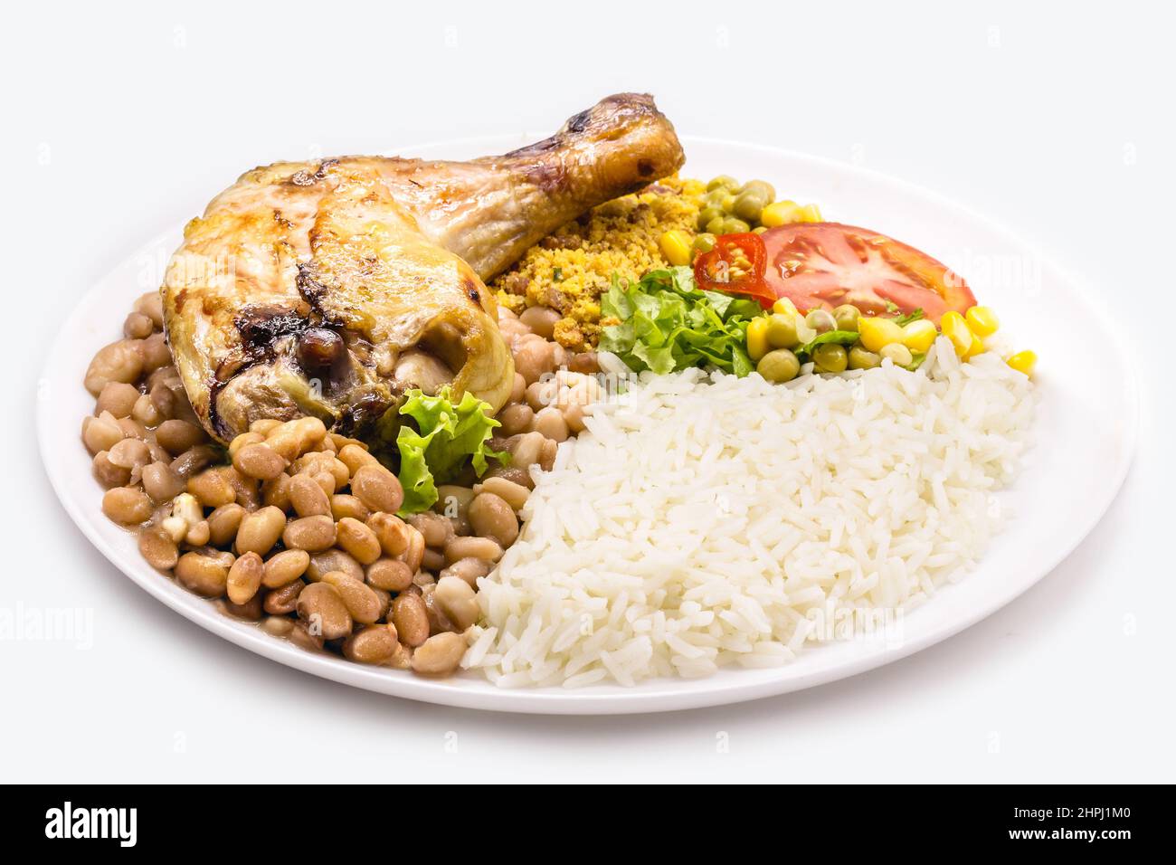 rice and beans dish, large roasted chicken thigh, chopped tomato salad ...