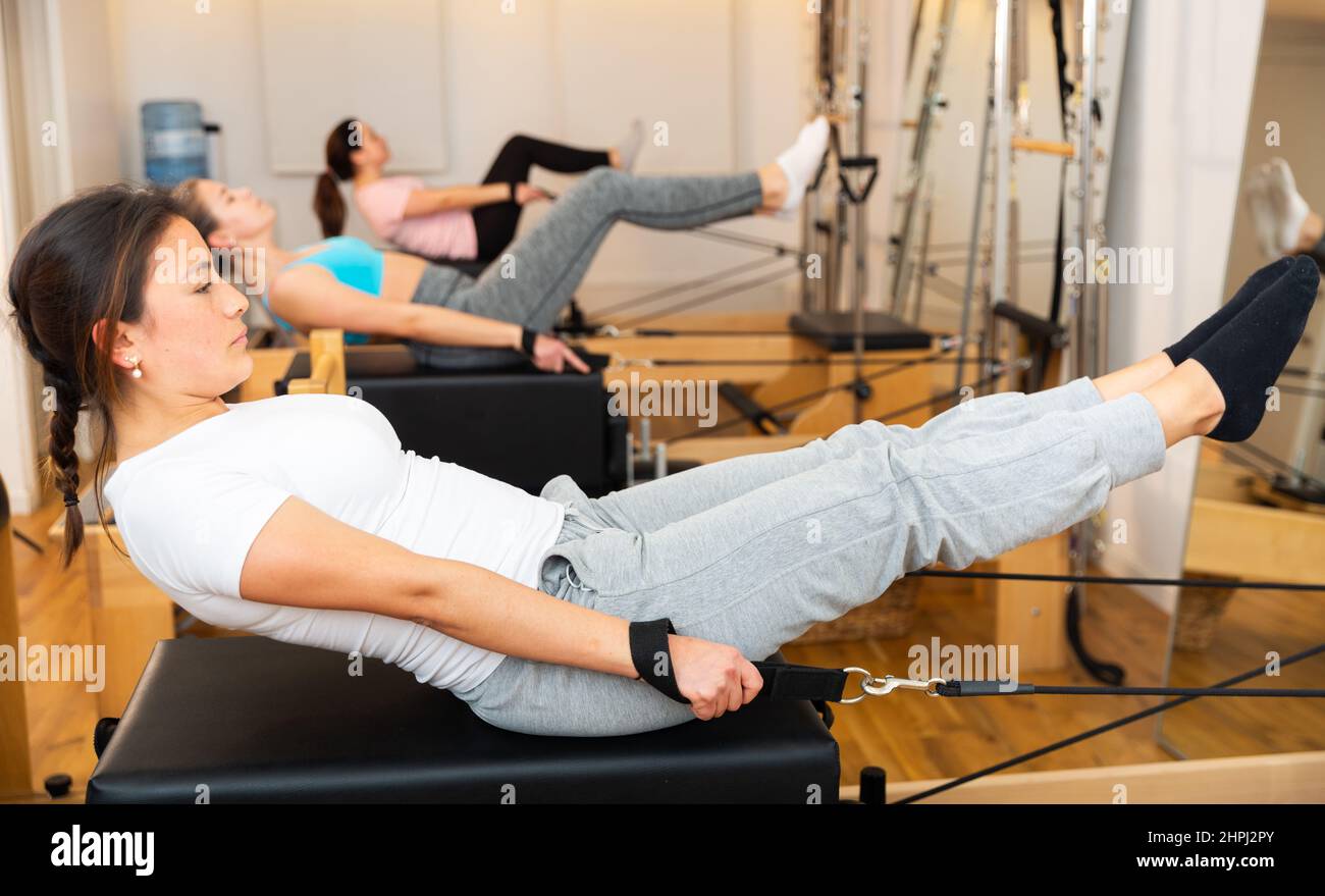 Women doing pilates exercises lying on pilates machines Stock Photo - Alamy
