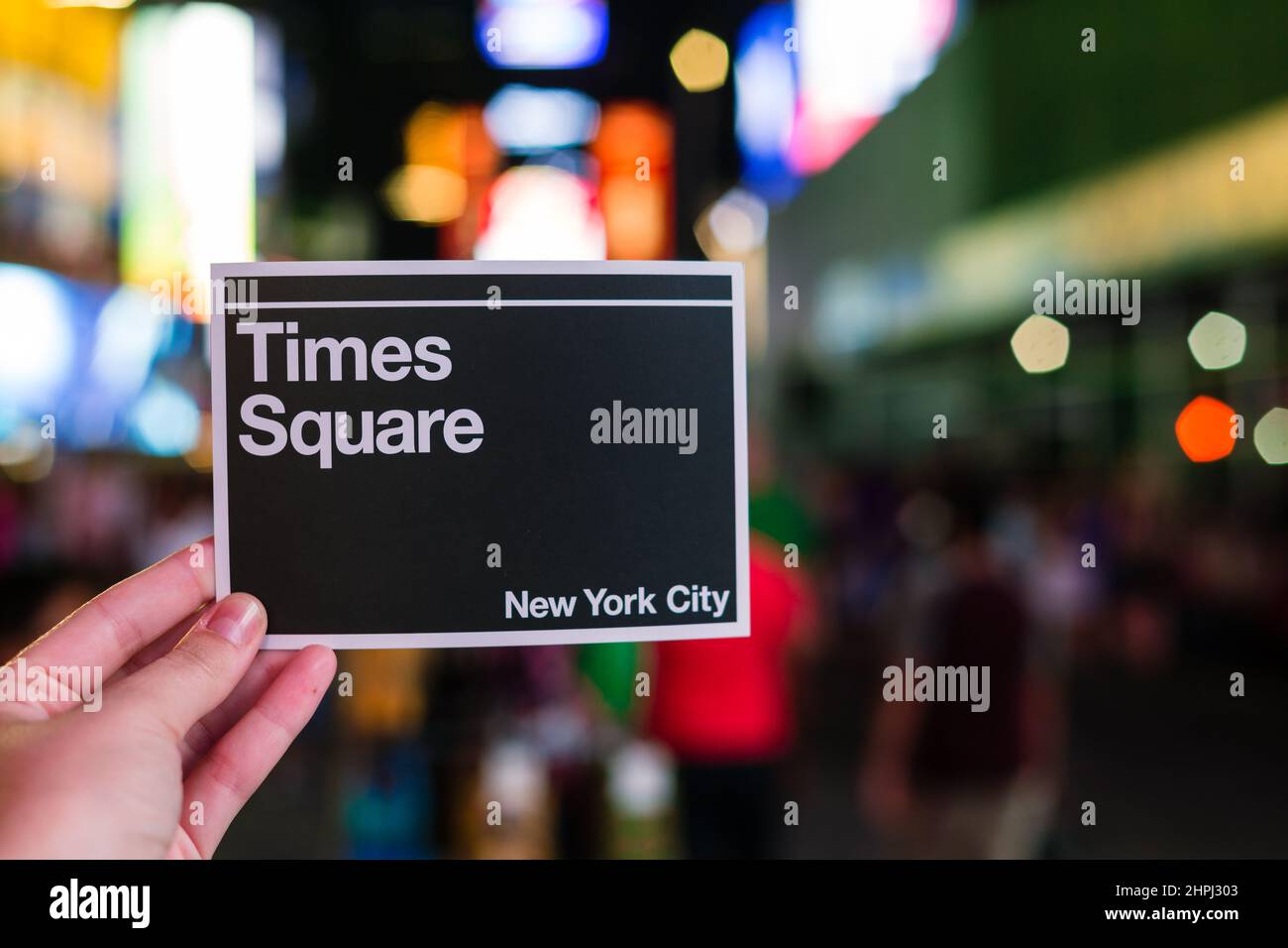 Shallow focus of a hand holding aTimes Square Postcard with bokeh ...