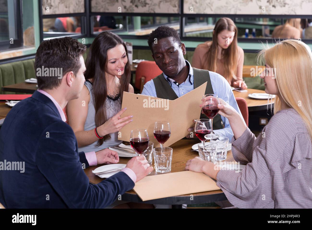 Happy people discussing restaurant menu Stock Photo - Alamy