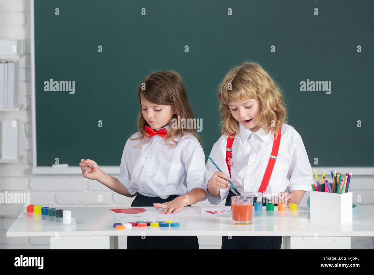 School children drawing a colorful pictures with pencil crayons in ...