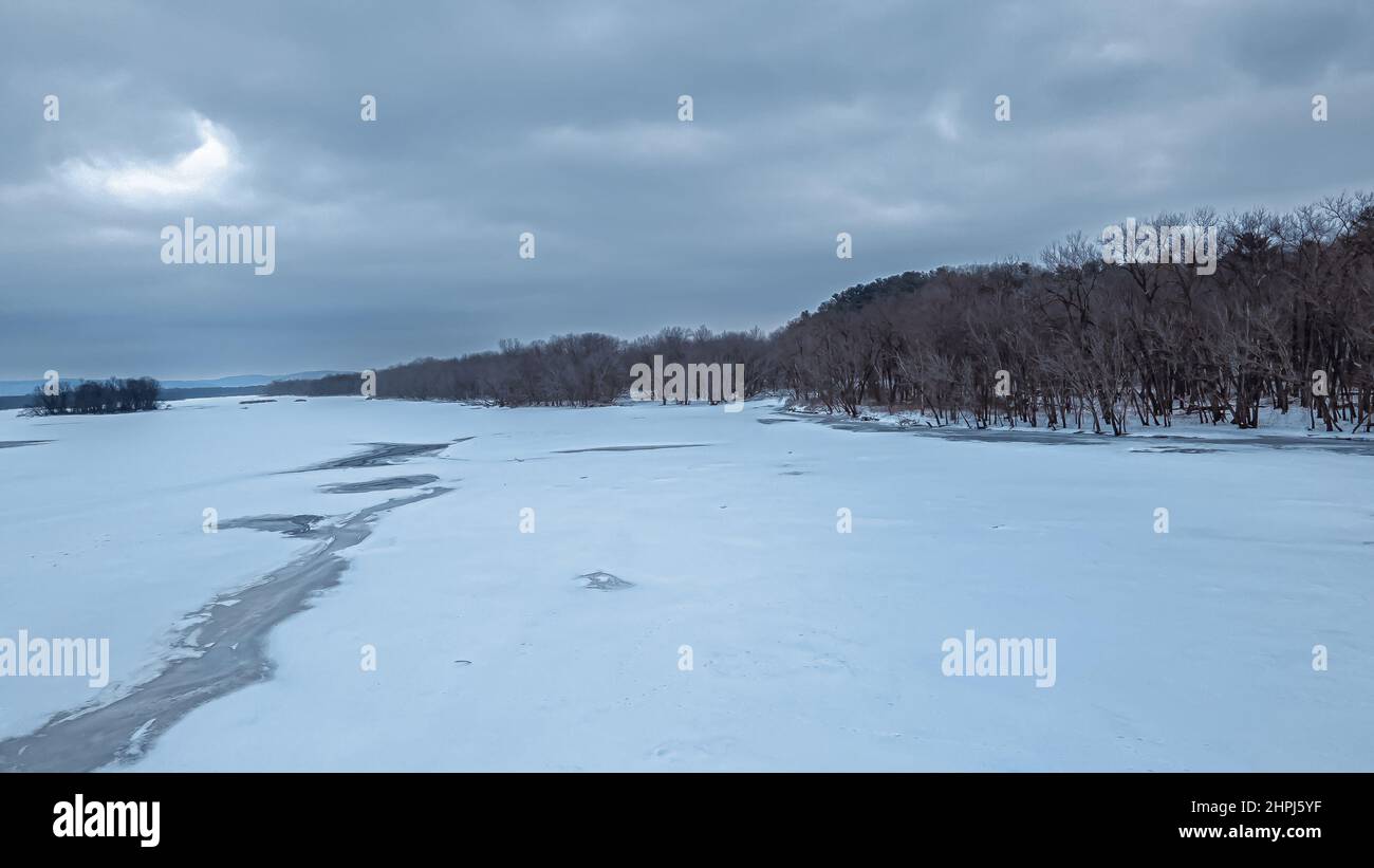 A cold view of the frozen river heading through the land Stock Photo ...