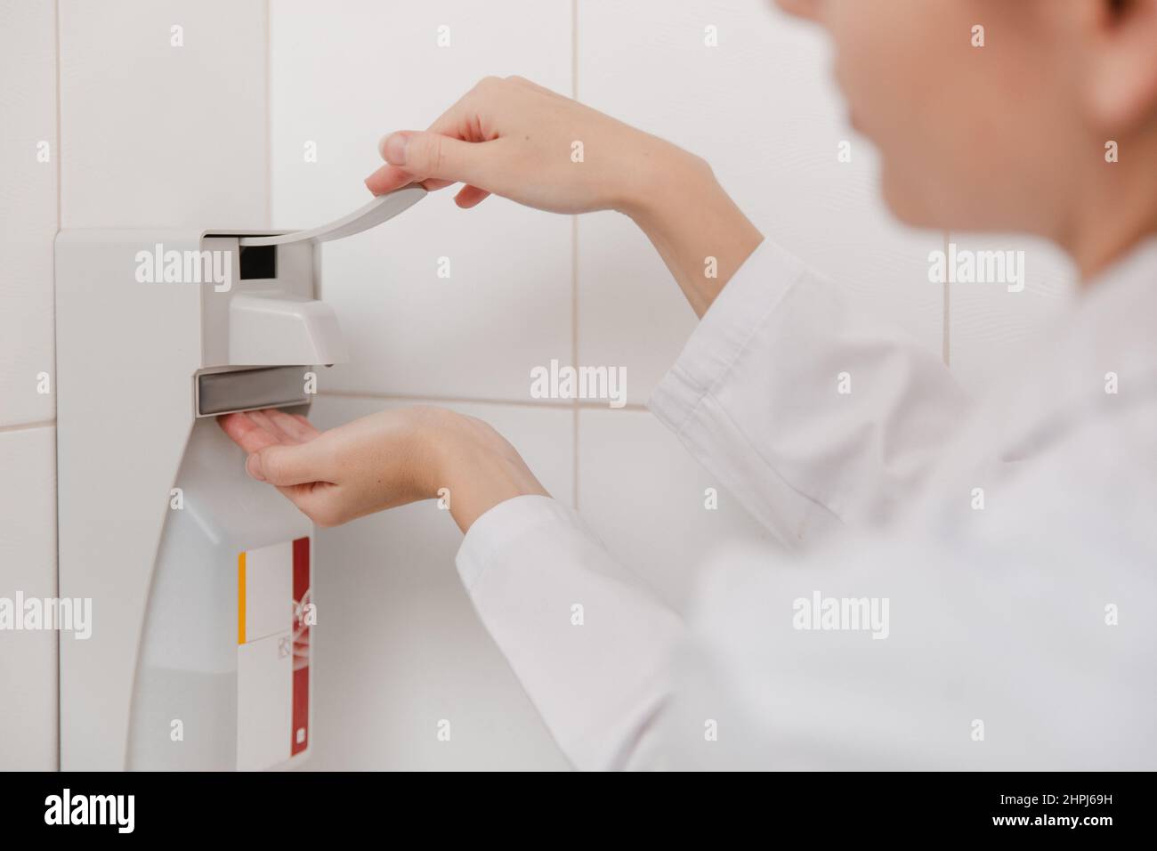 The doctor in white uniform disinfects his hands. Surgeon washing hands ...