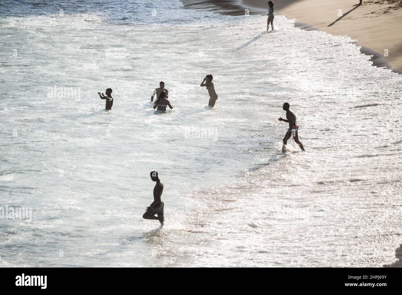 Scenic view of people bathing in the water at Paciencia beach in ...