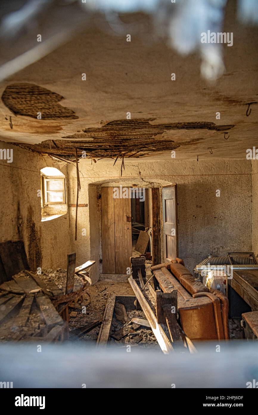 Ruined room with plastered walls and ceiling with open door on the ...