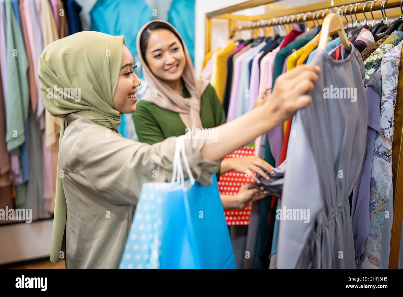 muslim female friend buying new dress at fashion store Stock Photo - Alamy
