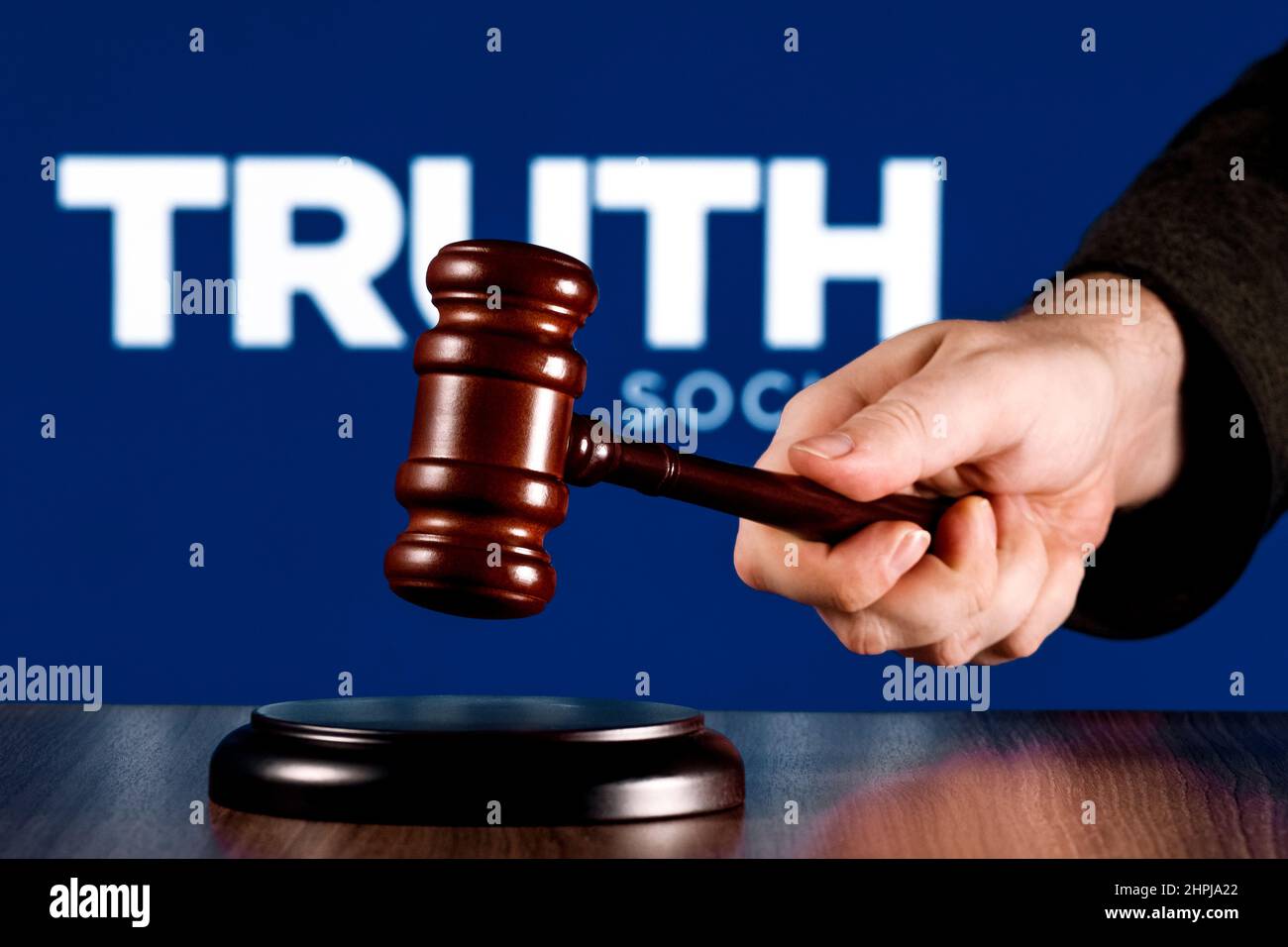 Gavel in judge hand against background of Truth Social network logo ...