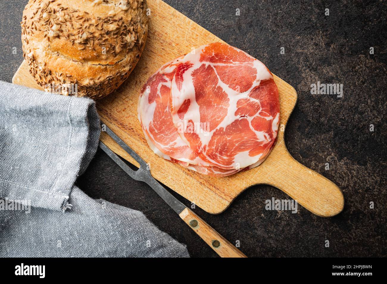 Italian dried ham. Coppa Stagionata on a cutting board. Top view Stock ...