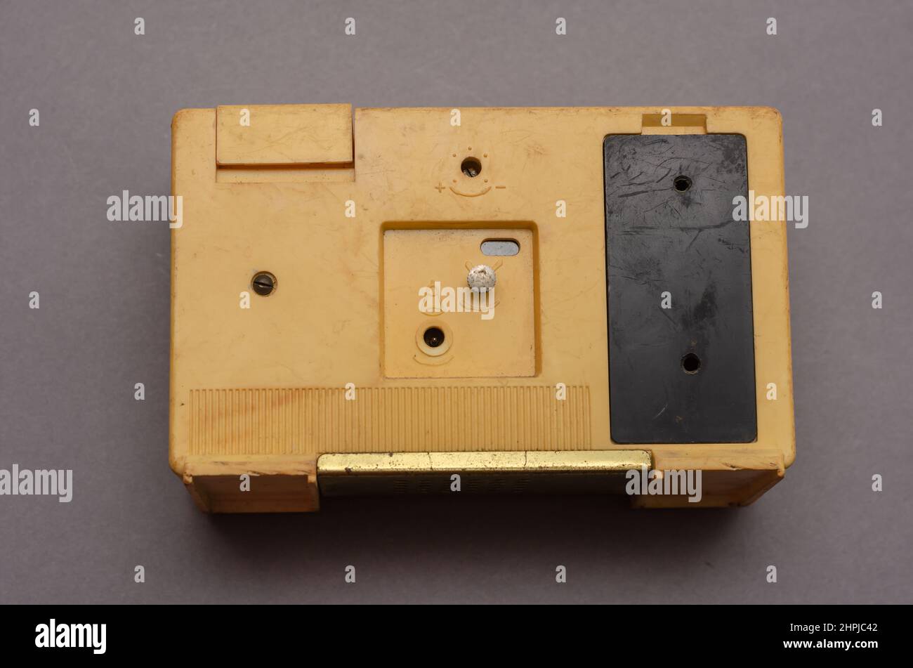 Vintage USSR. Back side of an old yellow alarm clock against a gray ...