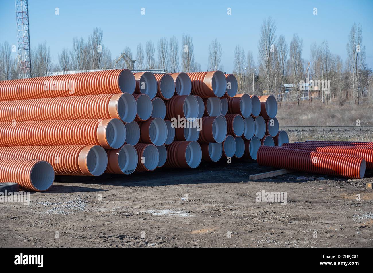 Stack of new orange polypropylene pipes outside. Plastic pipes for ...