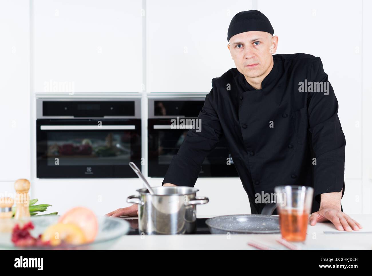 Smiling male kitchener in uniform is standing in the kitchen Stock ...